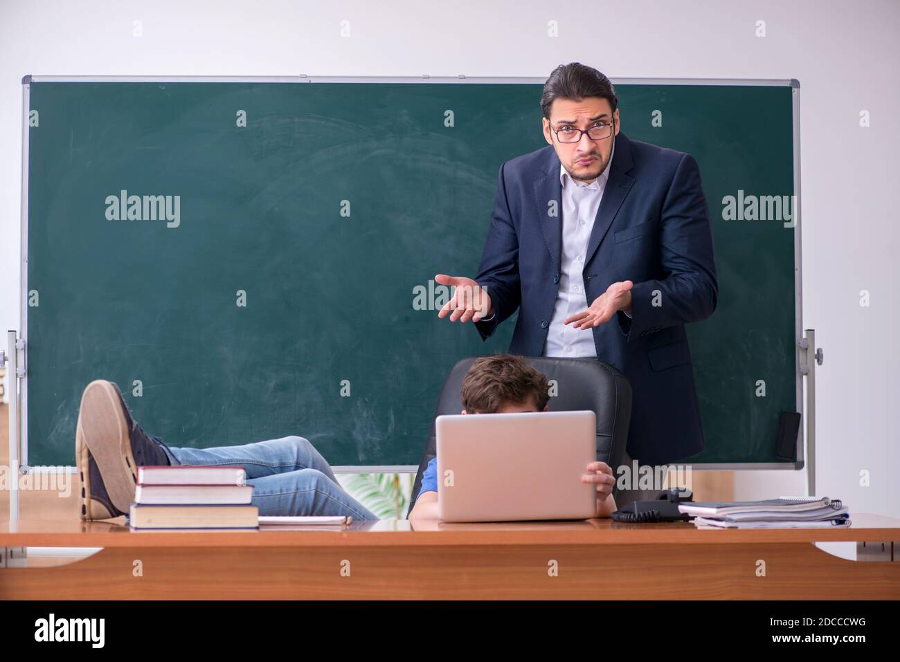 Male teacher and schoolboy in the classroom Stock Photo - Alamy