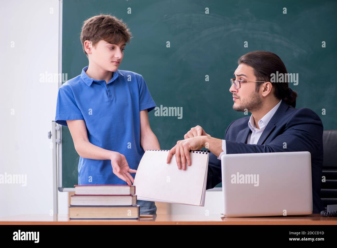 Male teacher and schoolboy in the classroom Stock Photo - Alamy