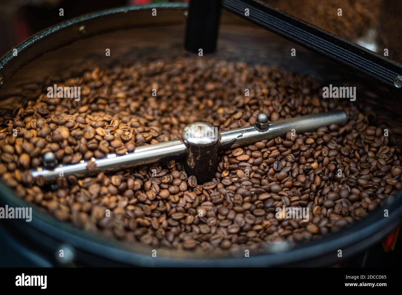 Mixing and roasting brown coffee beans on cooling plate - professional ...