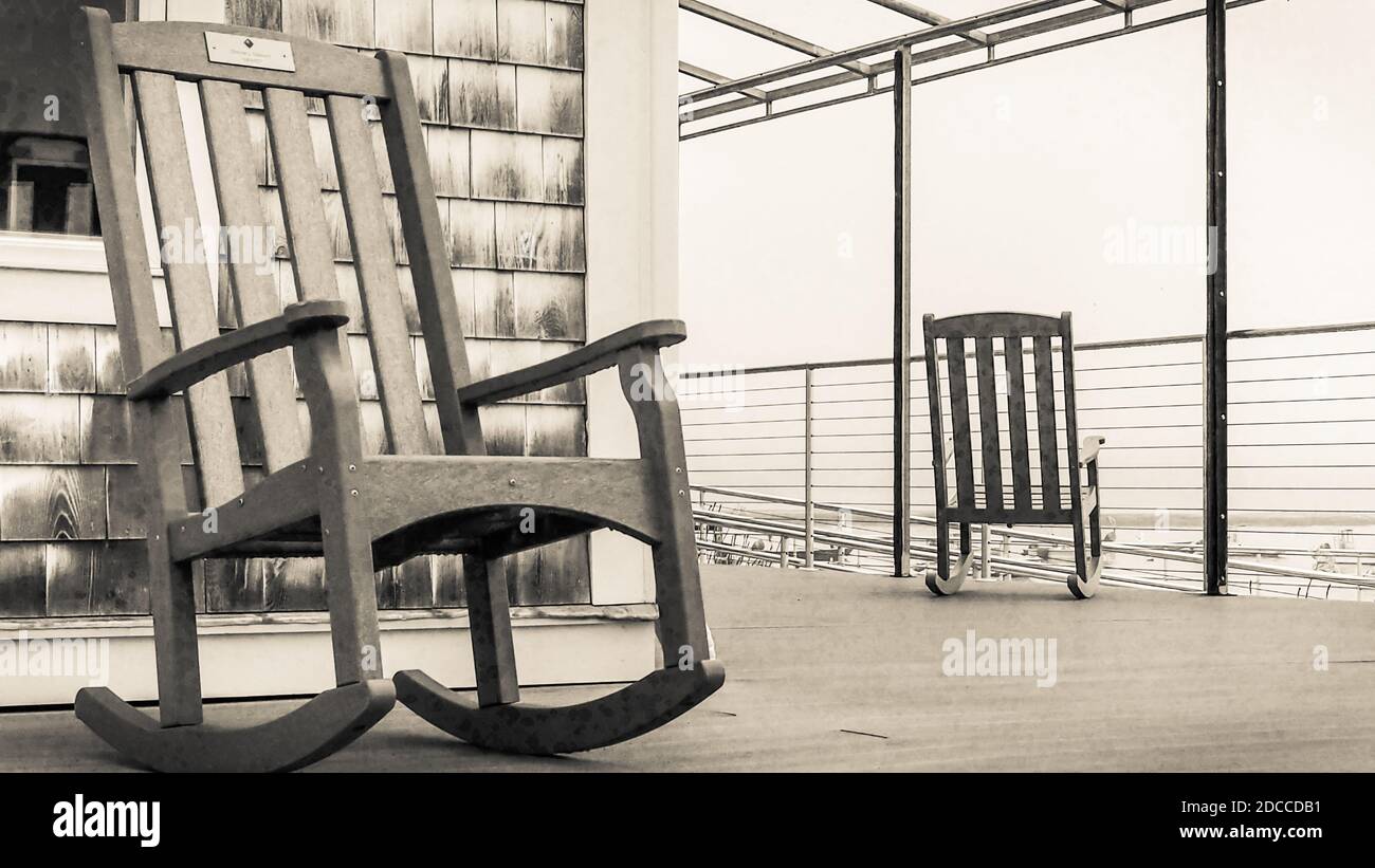 Empty rocking chair on the deck along the waterfront on a foggy morning ...