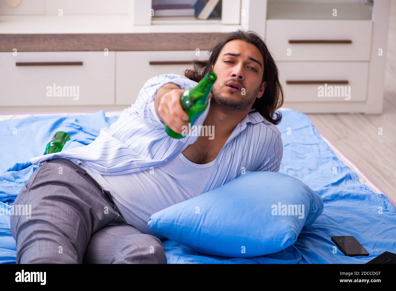 Male alcoholic in the bedroom Stock Photo - Alamy