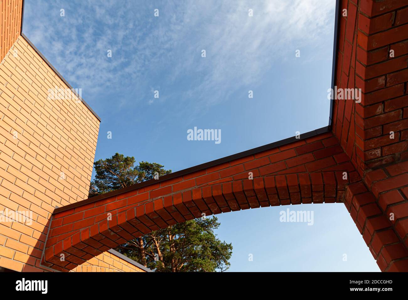 Corner of a brick building with arches on a background of blue sky with ...