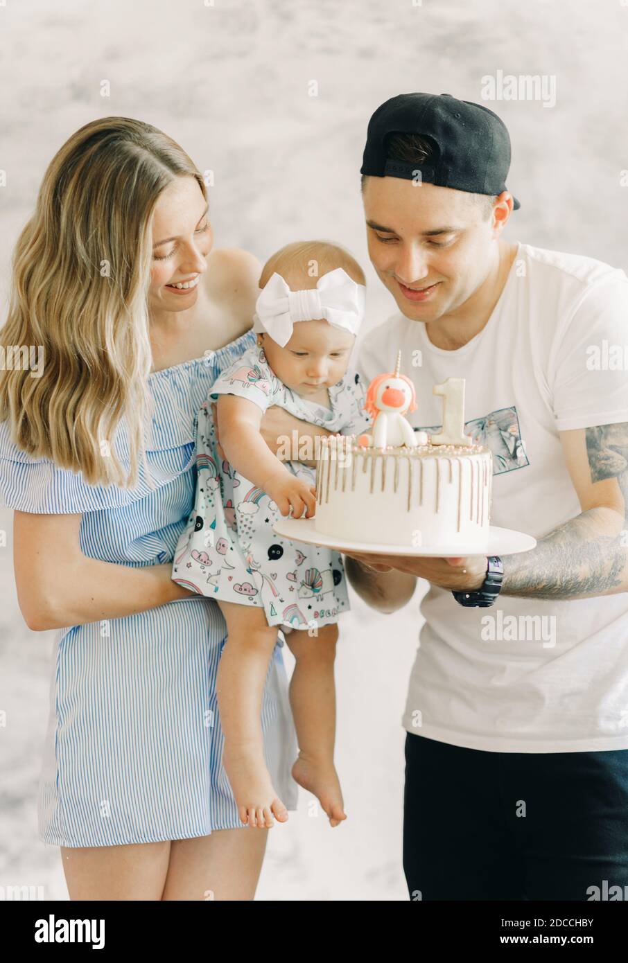 Young parents give birthday cake for the first year of birth their ...