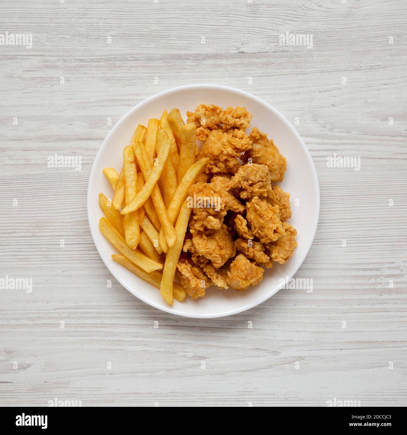 Homemade Fried Chicken Bites and French Fries on a plate on a white ...