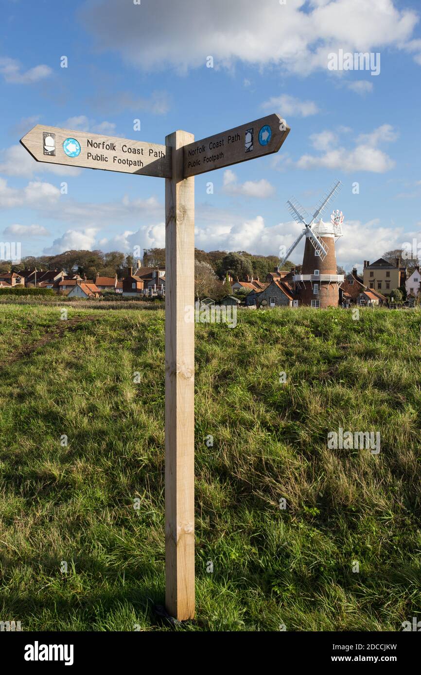 Sign post and sign for the Norfolk Coast Path with Cley windmill and ...