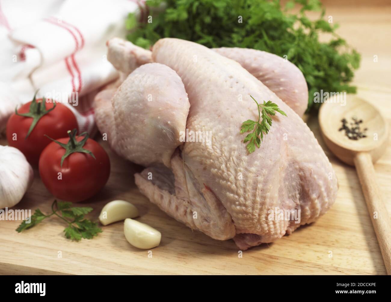 CHICKEN READY TO COOK WITH TOMATO, GARLIC AND PARSLEY Stock Photo - Alamy
