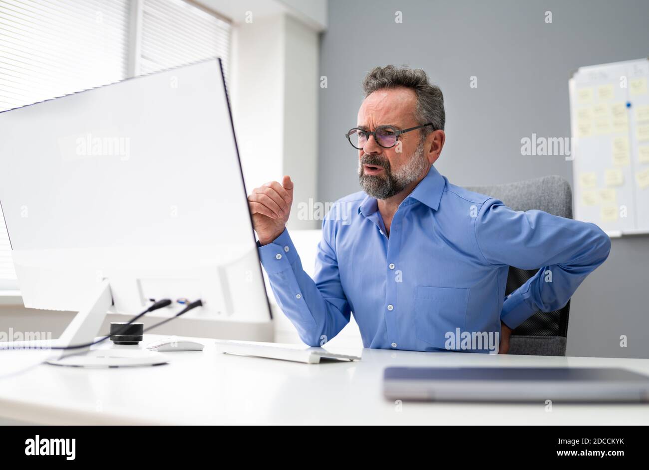 Back Pain At Computer In Office. Bad Posture Stock Photo - Alamy