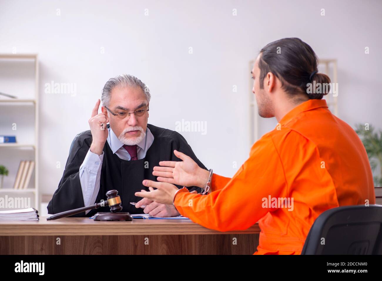 Old judge meeting with young captive in courthouse Stock Photo - Alamy