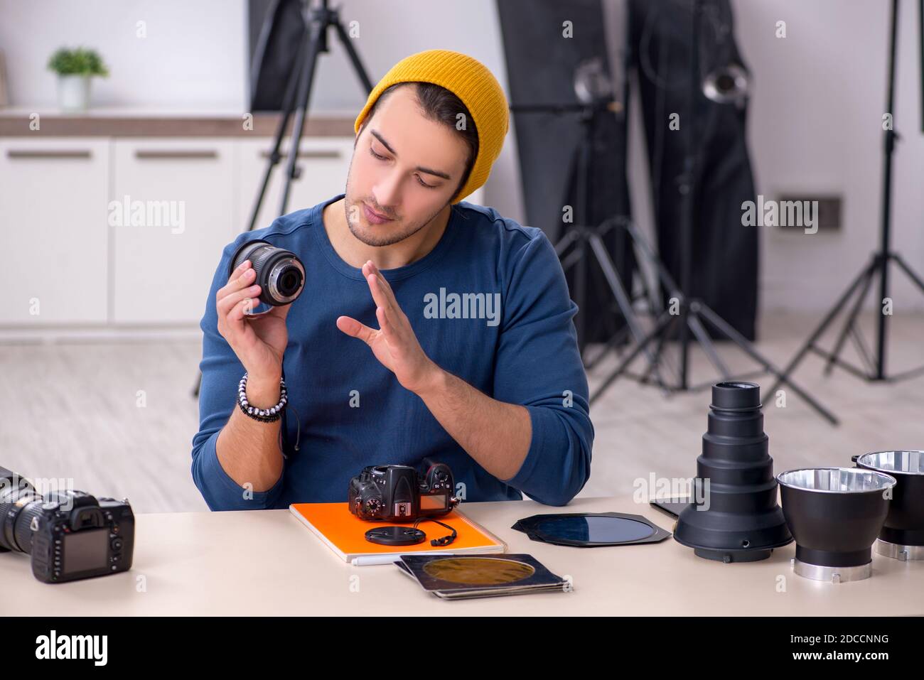 Young photographer working in the studio Stock Photo - Alamy