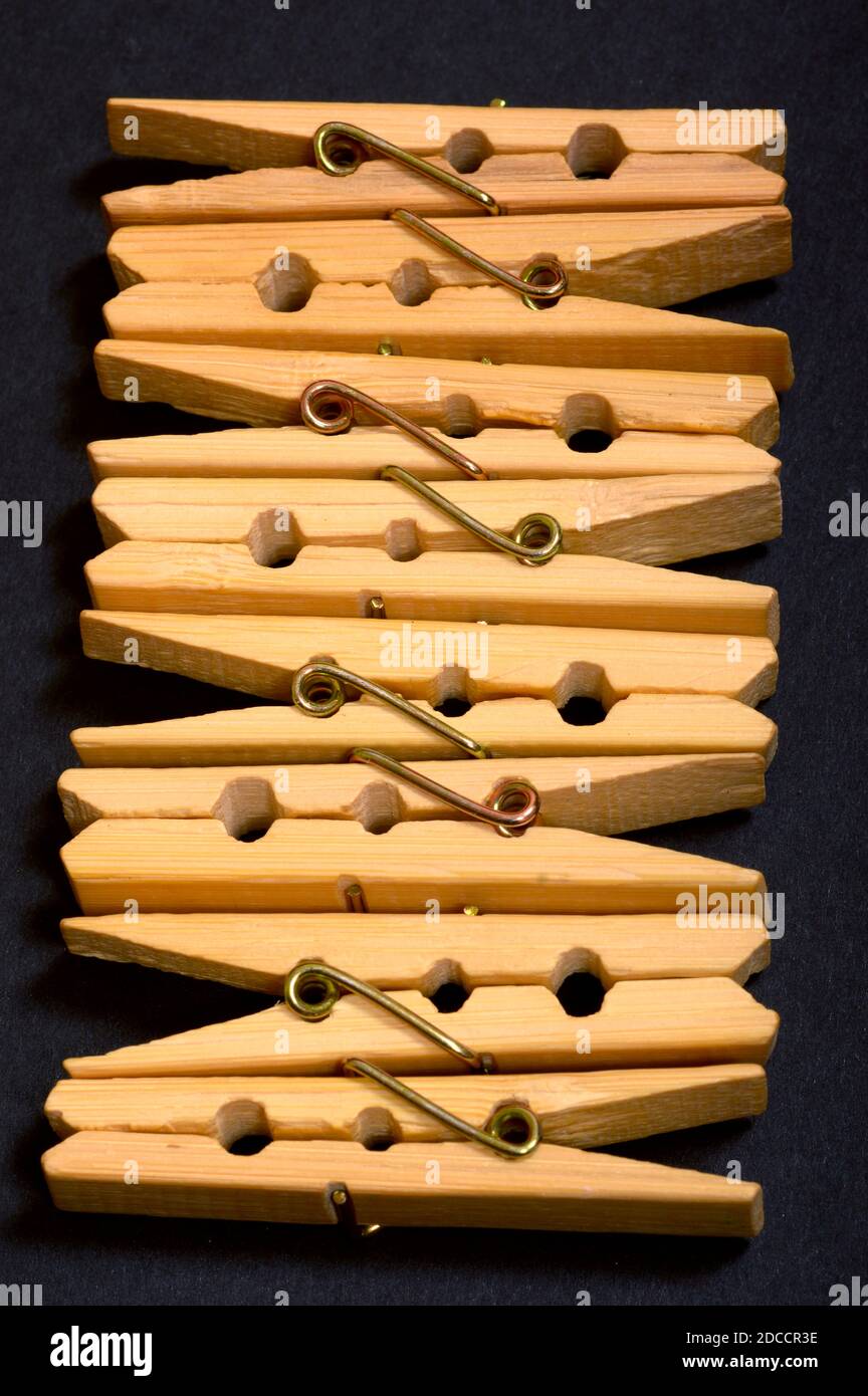 set of wooden clothes pin on a black background Stock Photo - Alamy