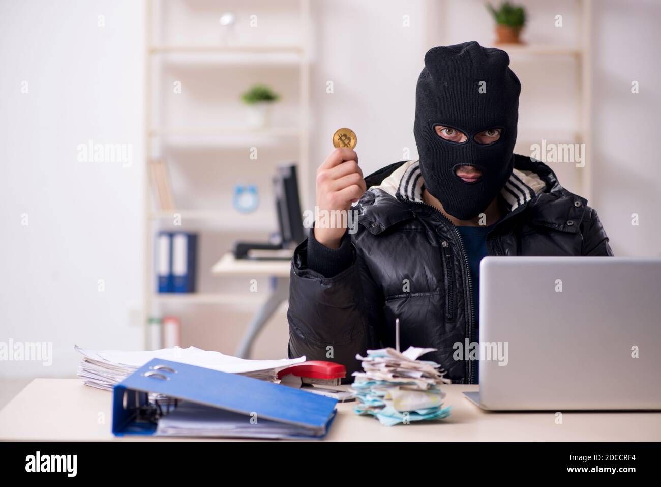 Young male burglar in the office room Stock Photo - Alamy