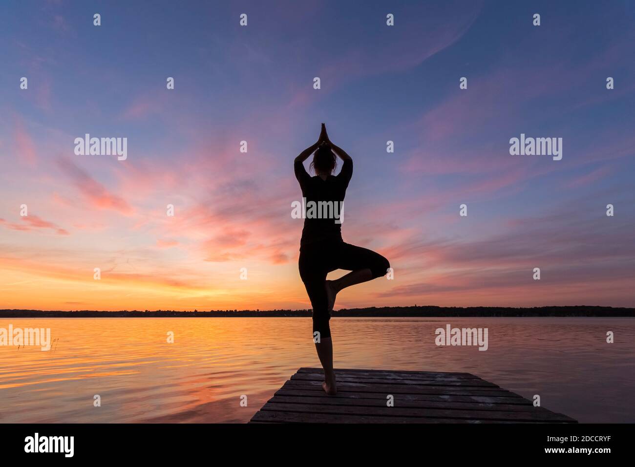 Woman practicing standing posture Vrikshasana / Tree Pose, one legged ...