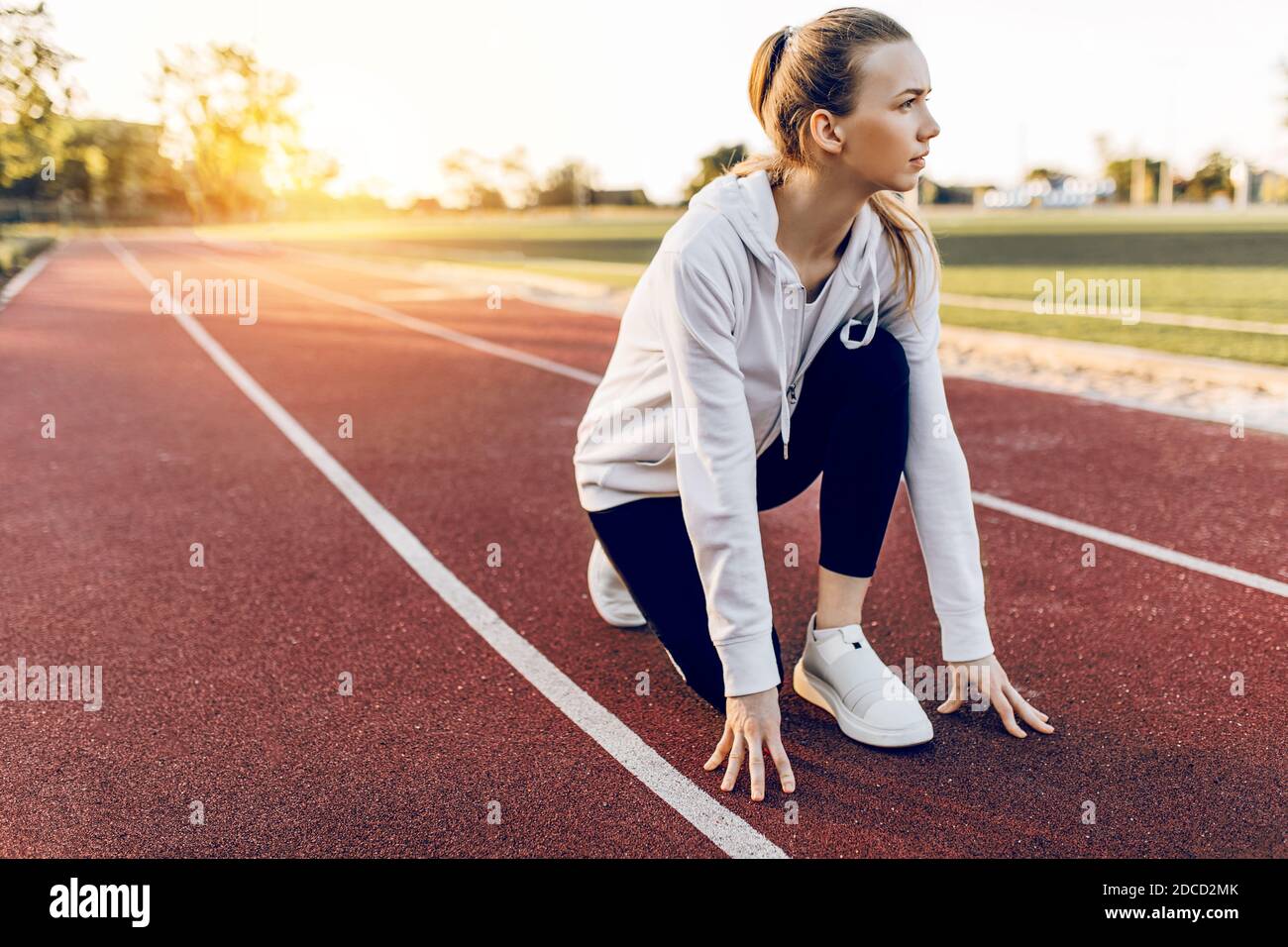 Athletic girl in sportswear, on the starting line in the race. A female ...