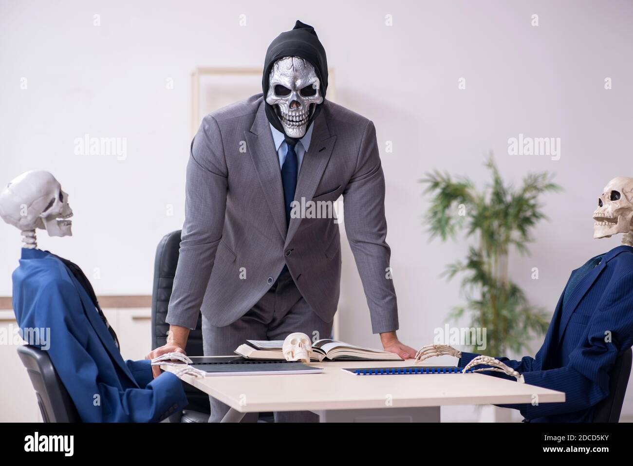Funny business meeting with the devil and skeletons Stock Photo - Alamy
