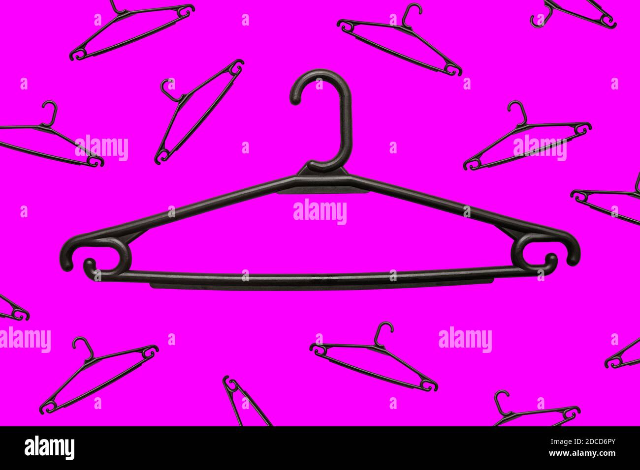 Large and small plastic hangers on a bright background. Black clothes ...