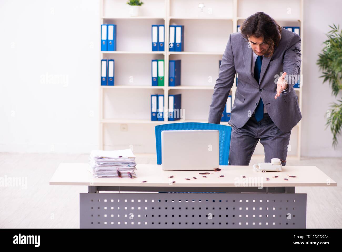 Young employee and too many cockroaches in the office Stock Photo - Alamy
