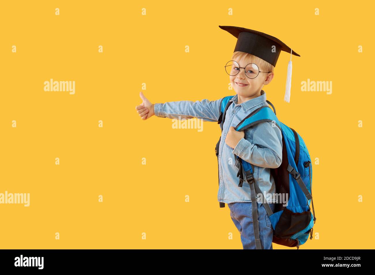 Child boy primary school student in a graduate cap, glasses and with a ...