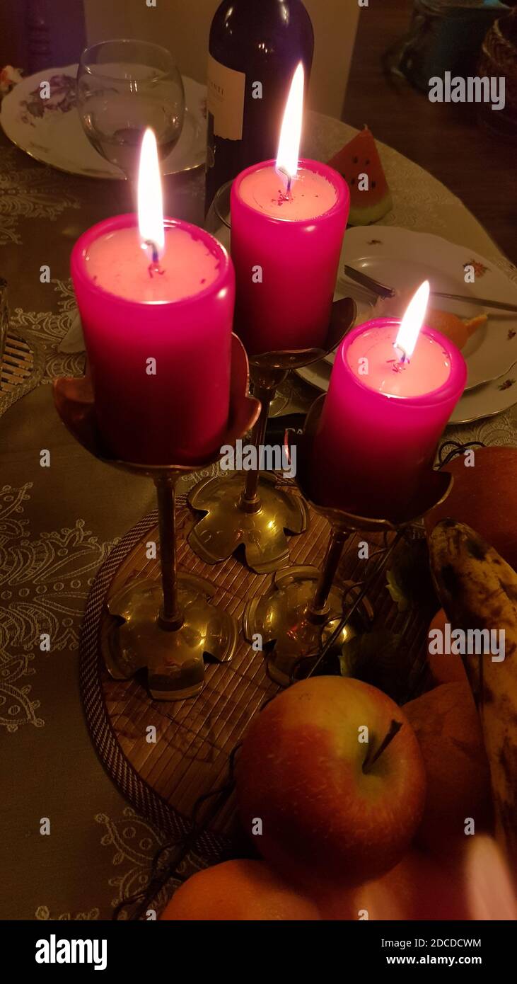 Holiday table with three red candles in vintage copper candelabras ...