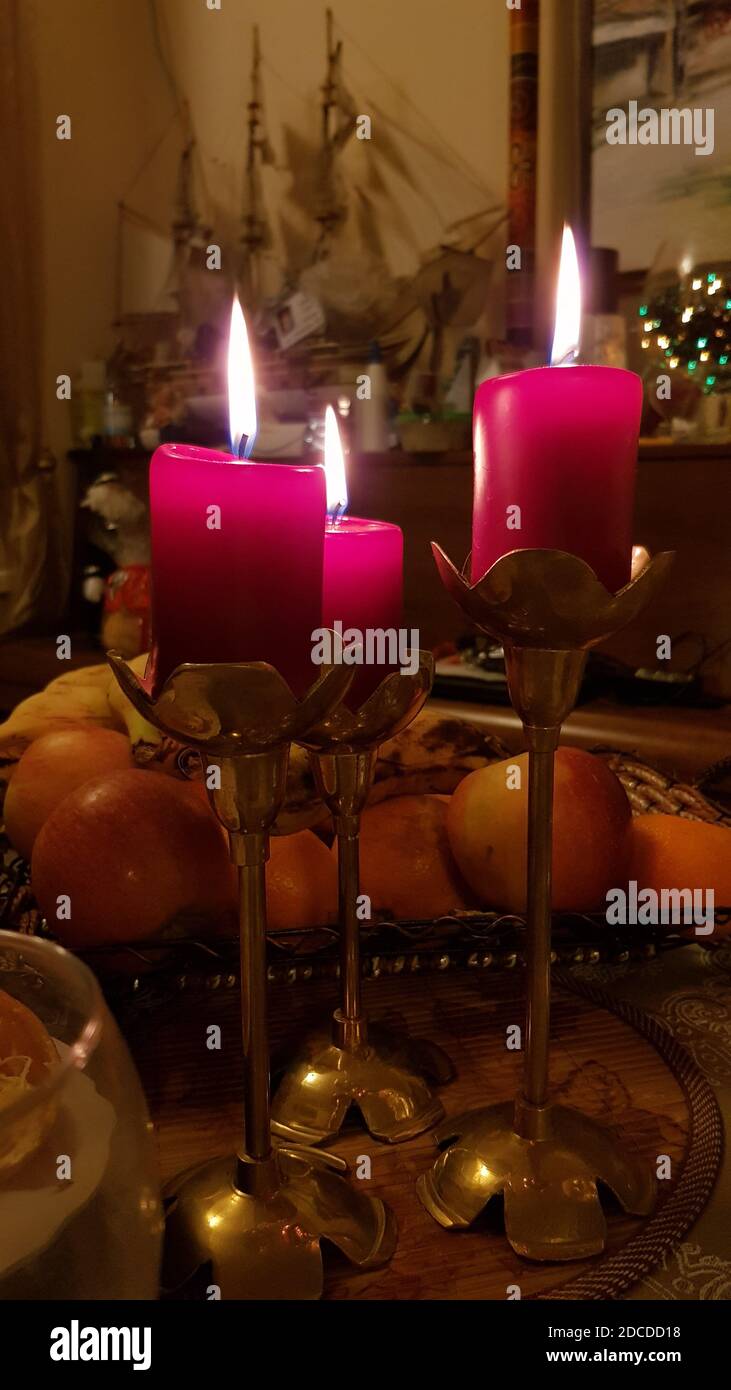 Still life with three red candles in vintage copper candelabras on ...