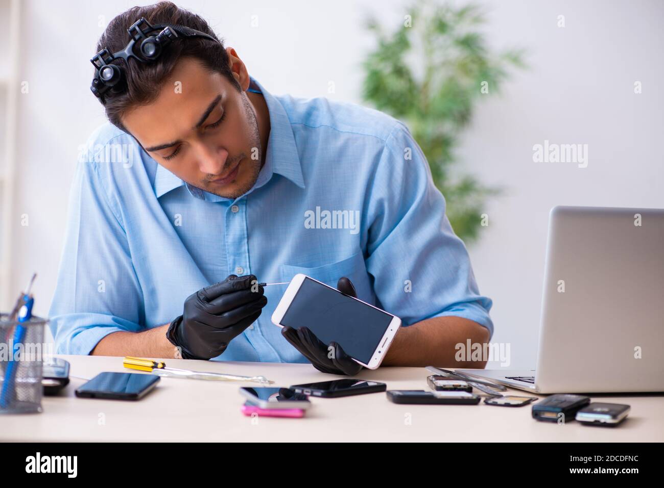 Young male technician repairing the mobile phone Stock Photo - Alamy
