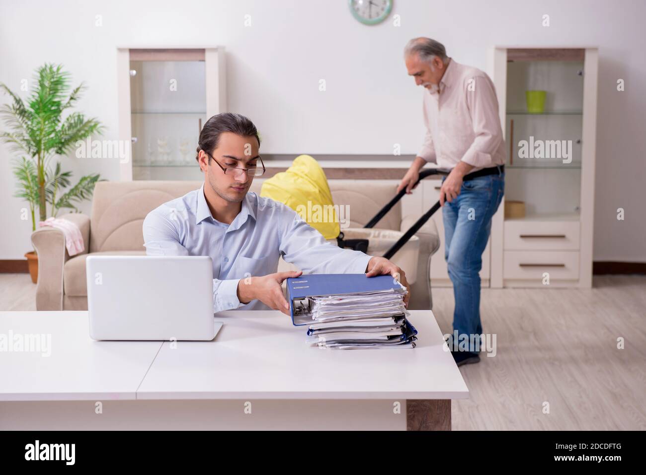 Old grandfather looking after newborn at home Stock Photo - Alamy