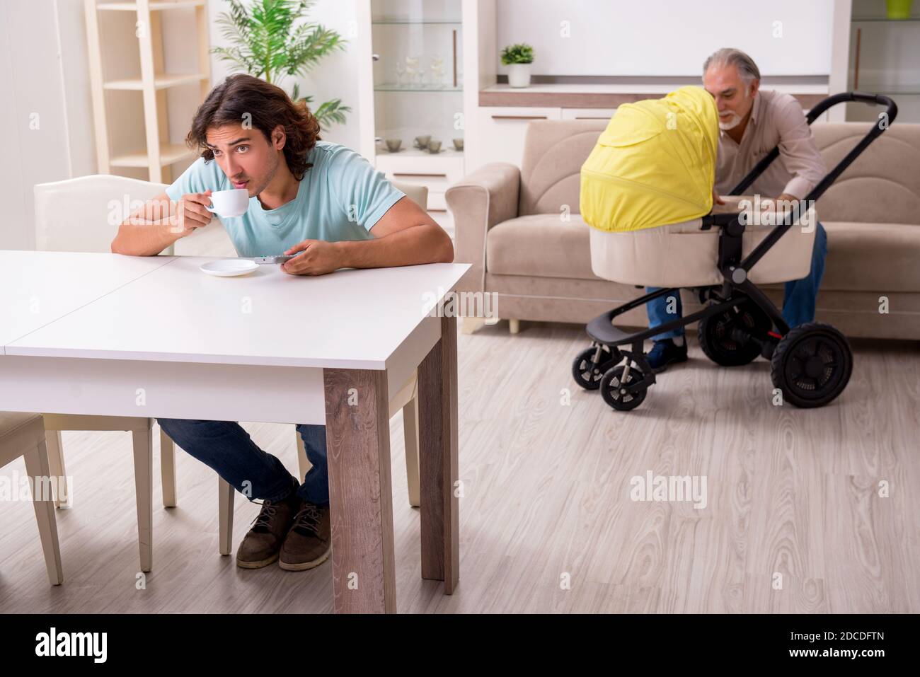 Old grandfather looking after newborn at home Stock Photo - Alamy