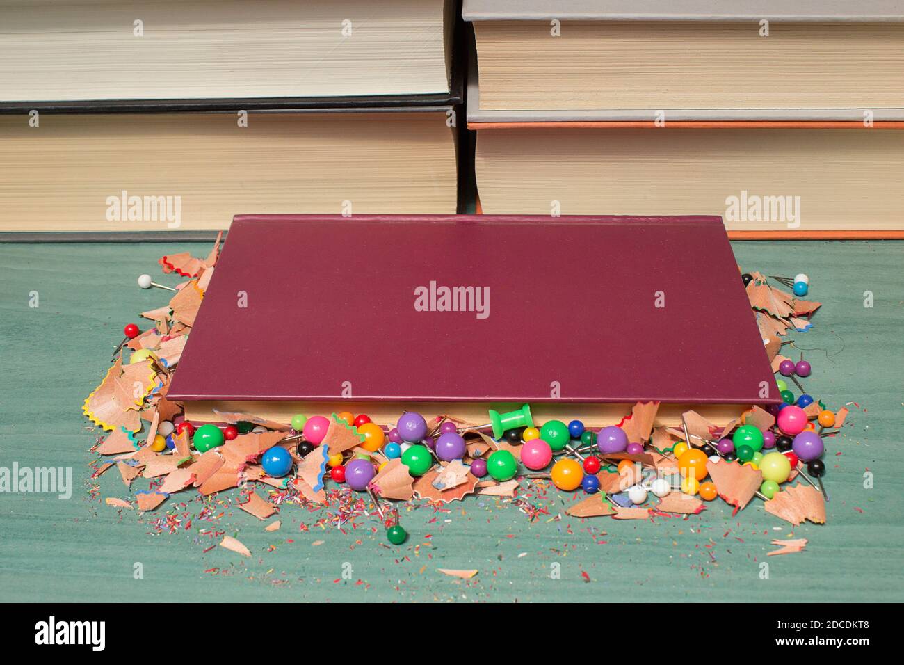 Close up shot of a small red book with colored pencil shavings and ...