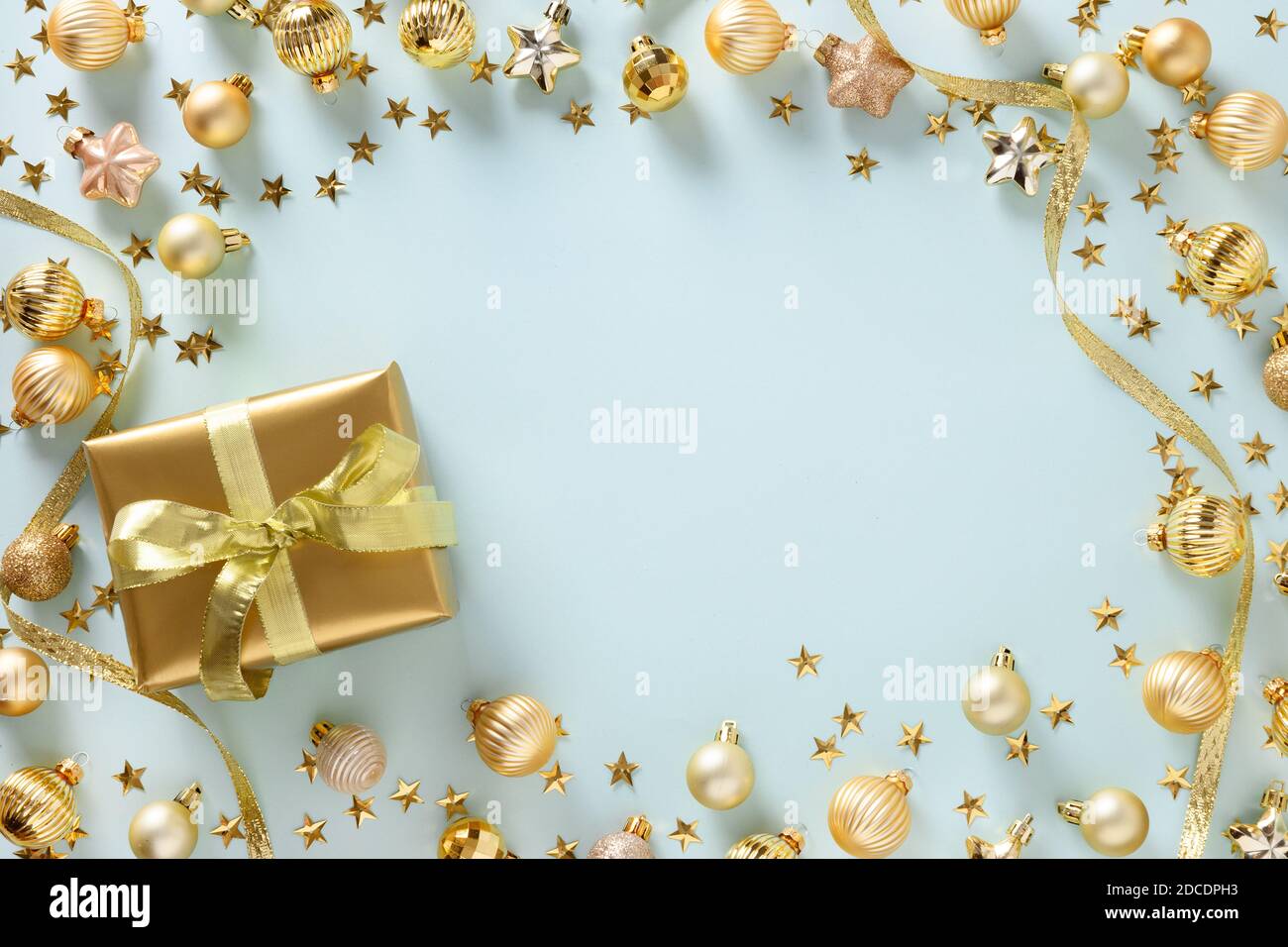 Christmas frame of golden gift and balls on blue. Top view. Xmas border ...