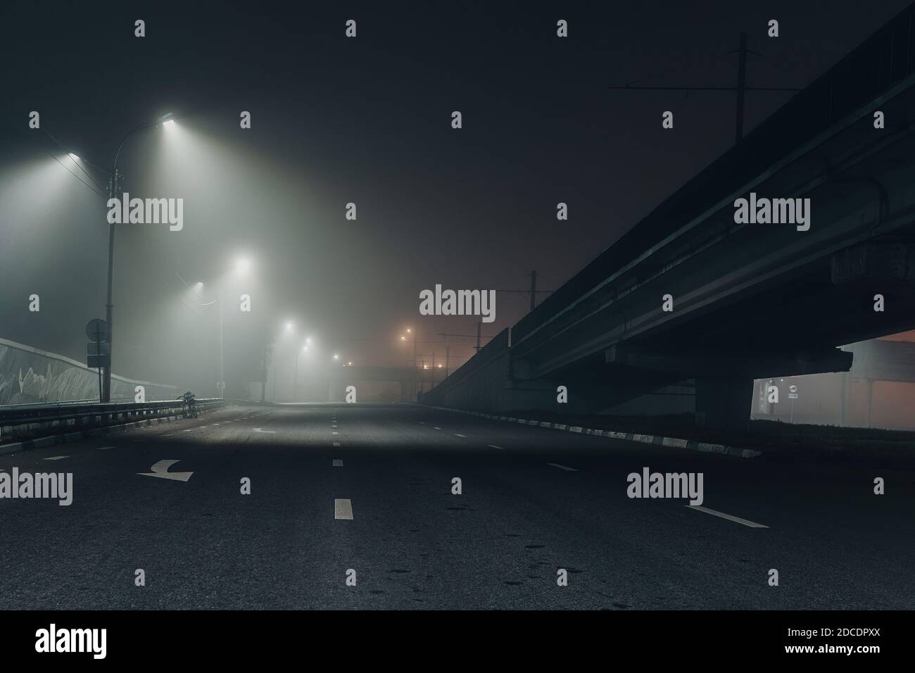 Foggy misty night road illuminated by street lights Stock Photo - Alamy