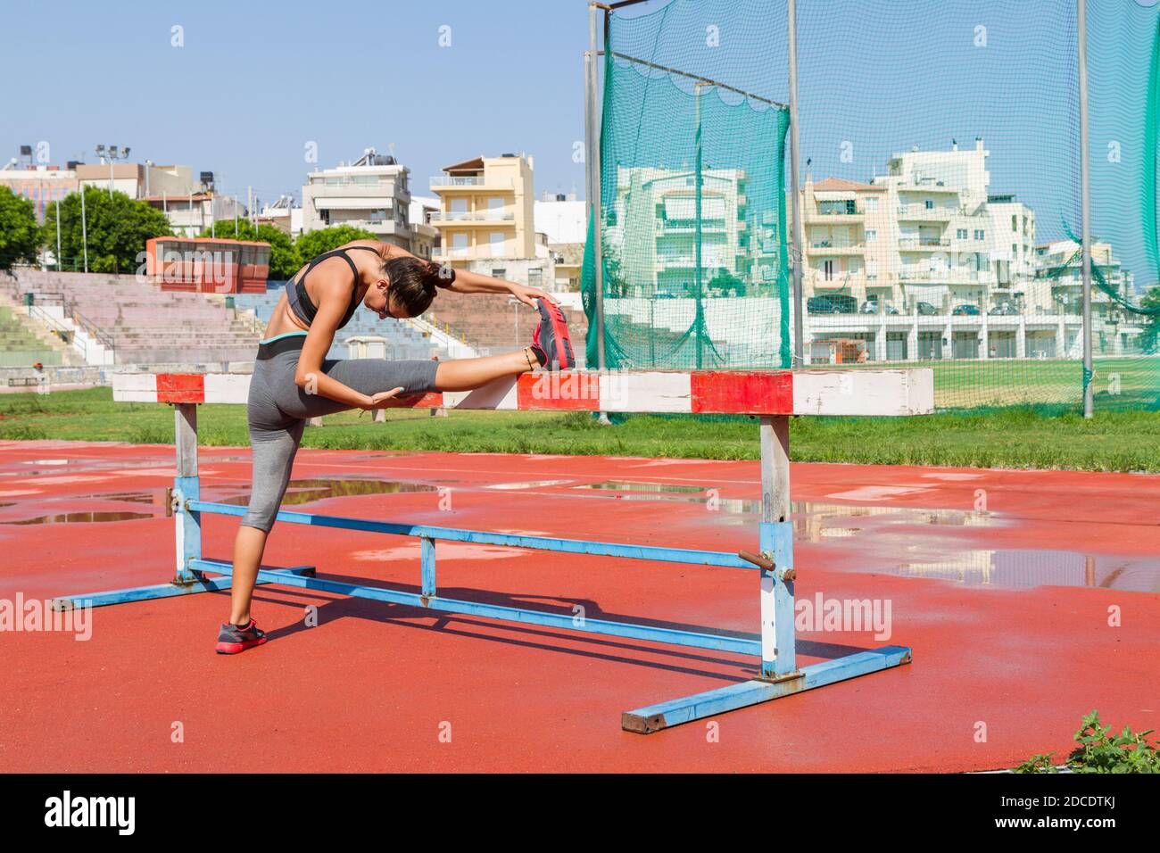 Young woman athlete doing stretching fitness workout at the local ...