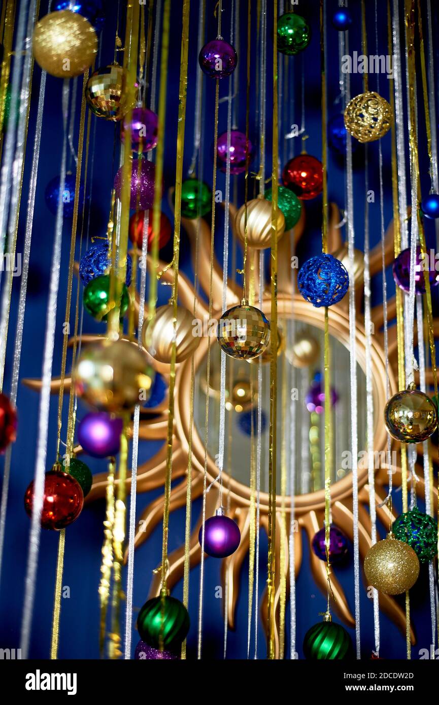 New Year's garland of balls and rain against the blue wall. Bright ...