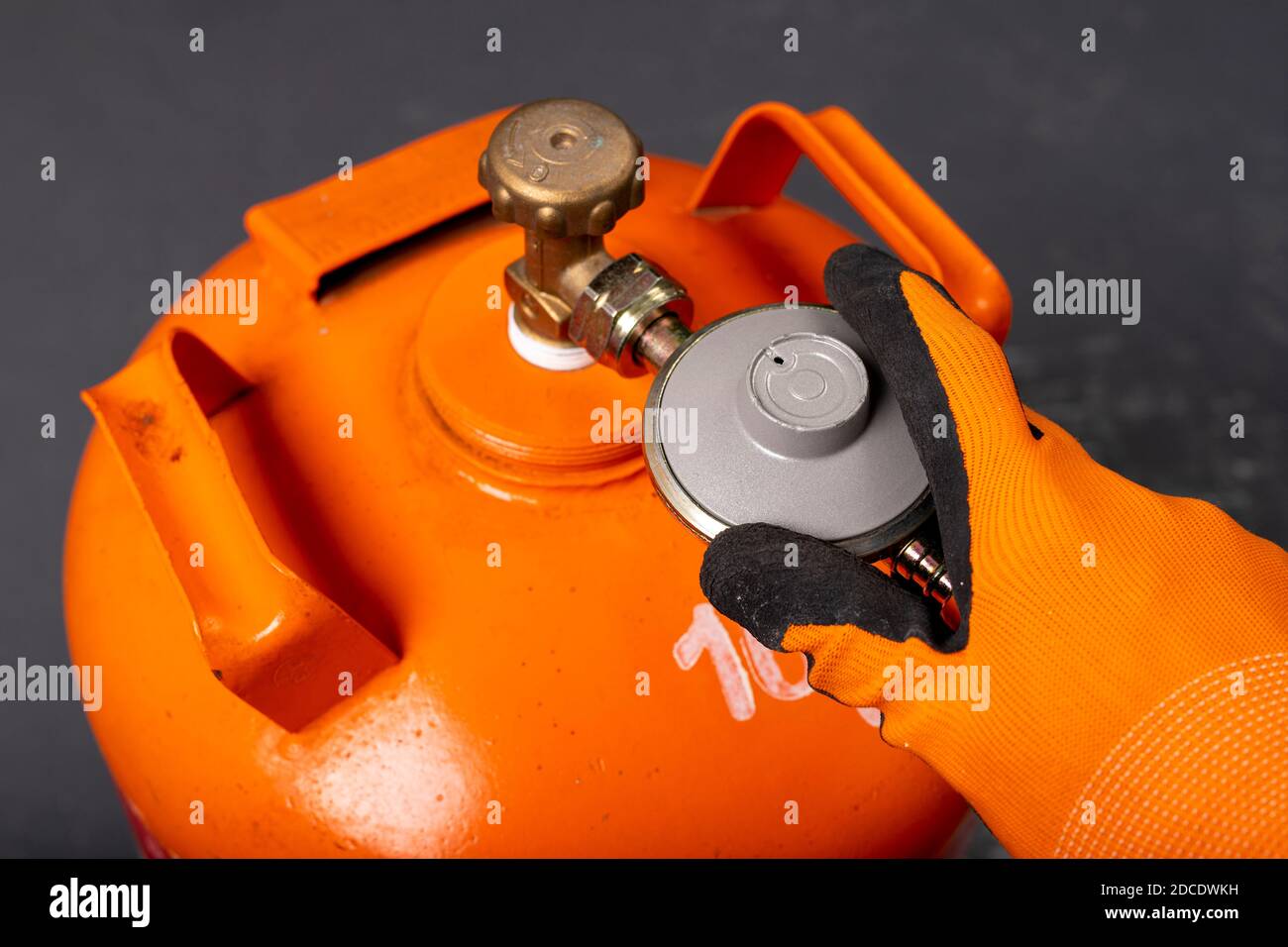 Unscrewing the propane-butane gas cylinder. Combustible gas used in ...