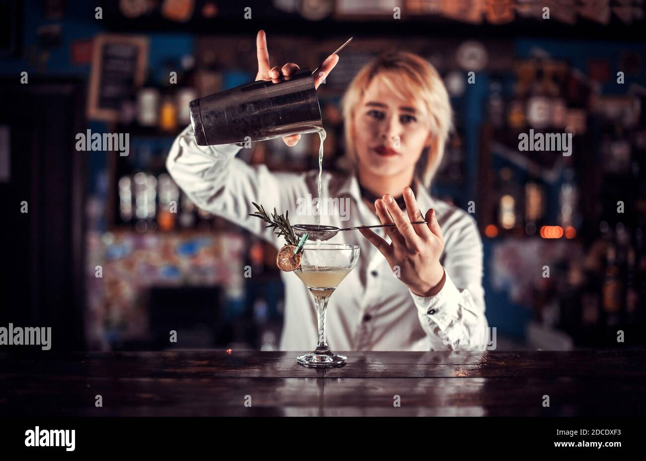 Charming woman bartending mixes a cocktail at the bar counter Stock ...
