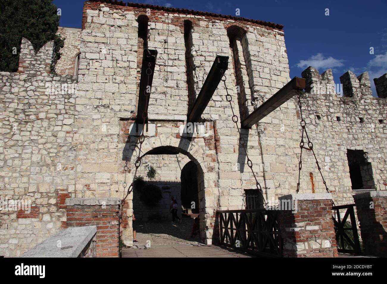 Stone wall with merlons and drawbridge gate of medieval castle of ...