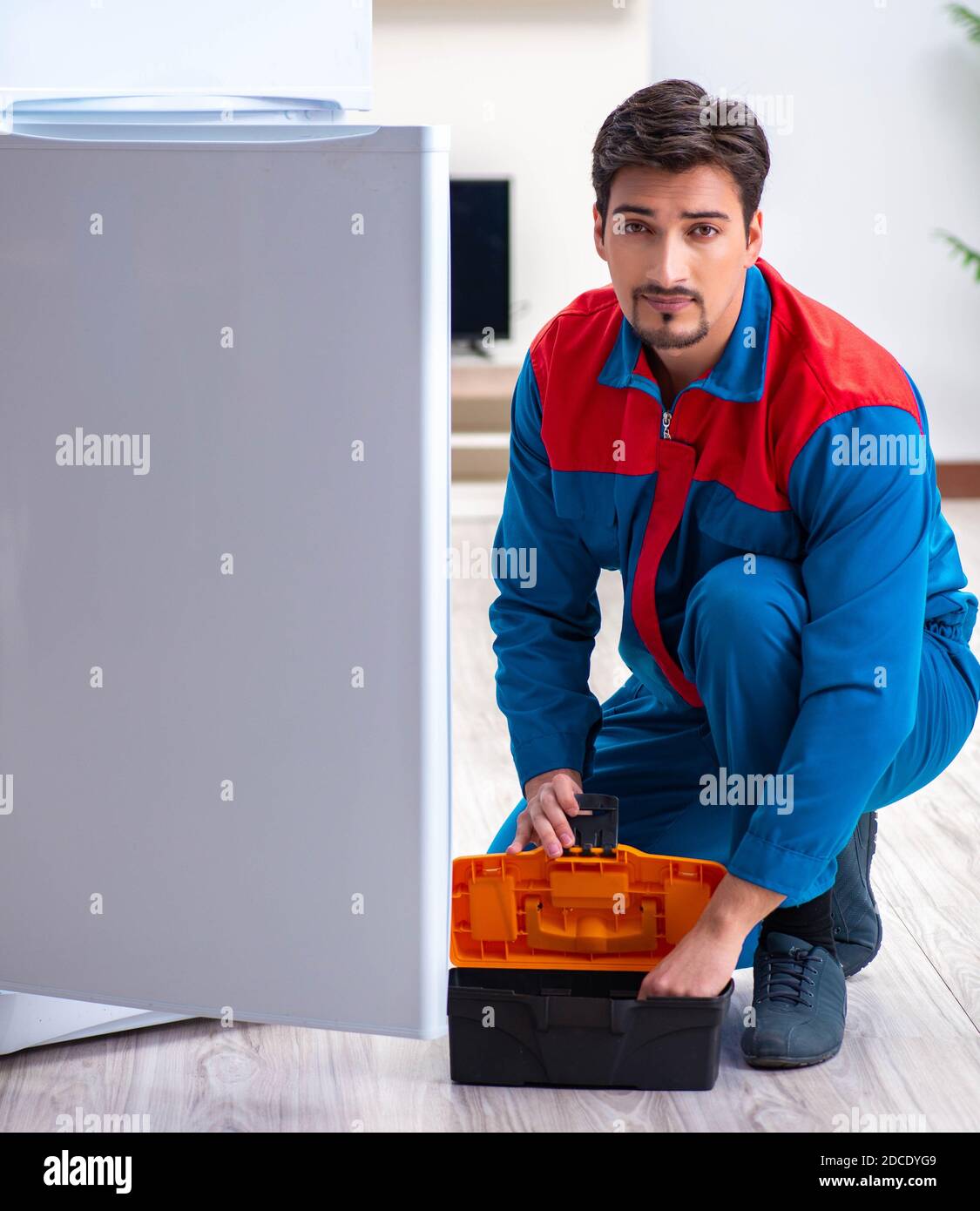 The professional contractor repairing broken fridge Stock Photo - Alamy