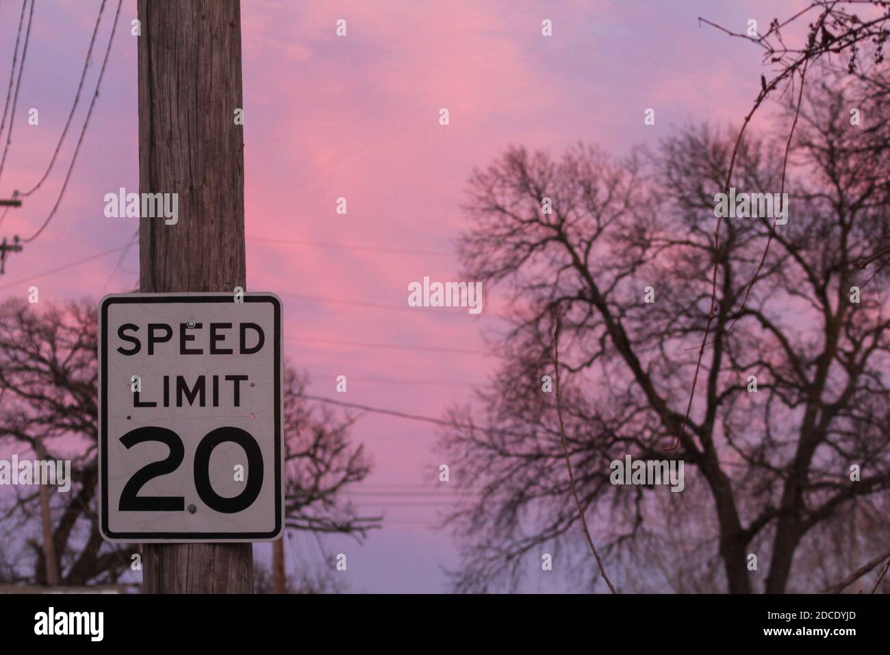 Pink sunset with the focus on the speed limit sign Stock Photo - Alamy