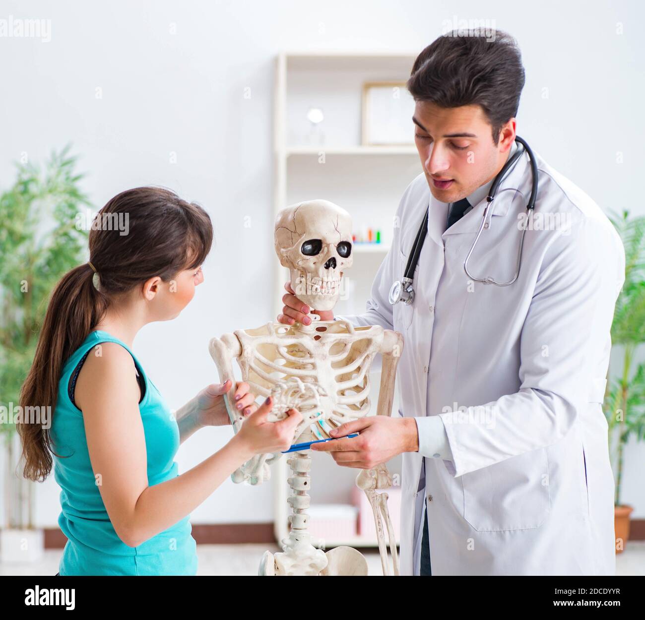 The doctor showing type of injury on skeleton to patient Stock Photo ...