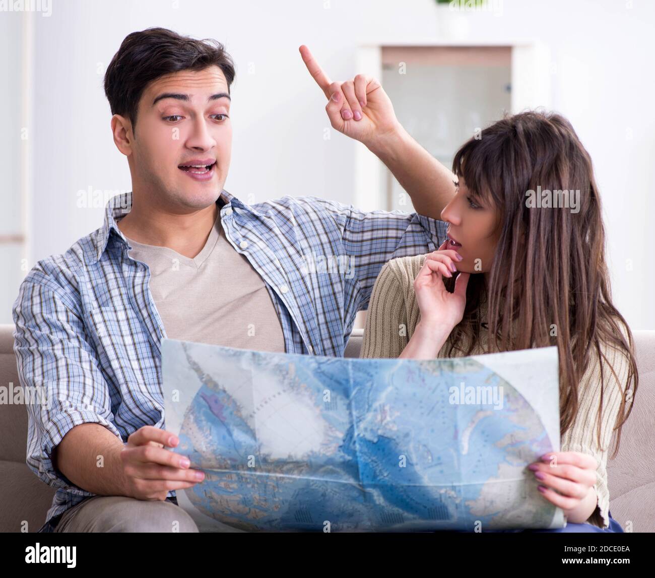 The young family discussing travel plans with map Stock Photo - Alamy