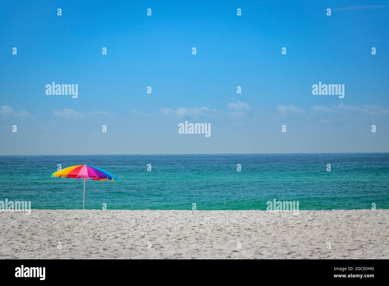 isolated colourful rainbow sun parasol shade with sand and sea at beach ...