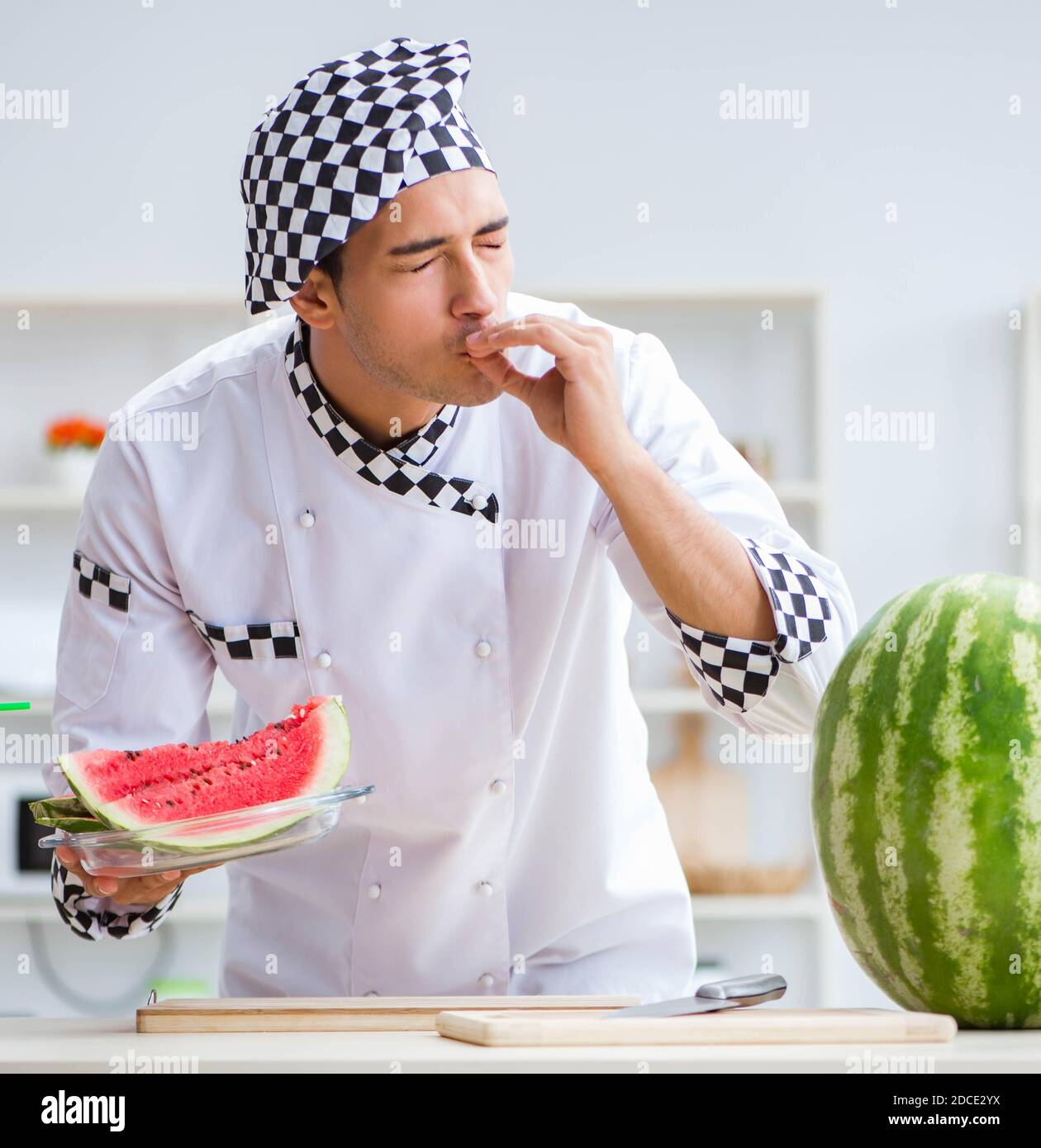 The male cook with watermelon in kitchen Stock Photo - Alamy