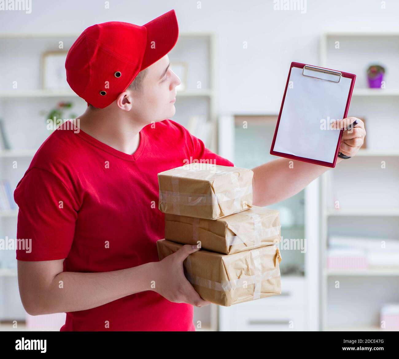 The post man delivering a parcel package Stock Photo - Alamy