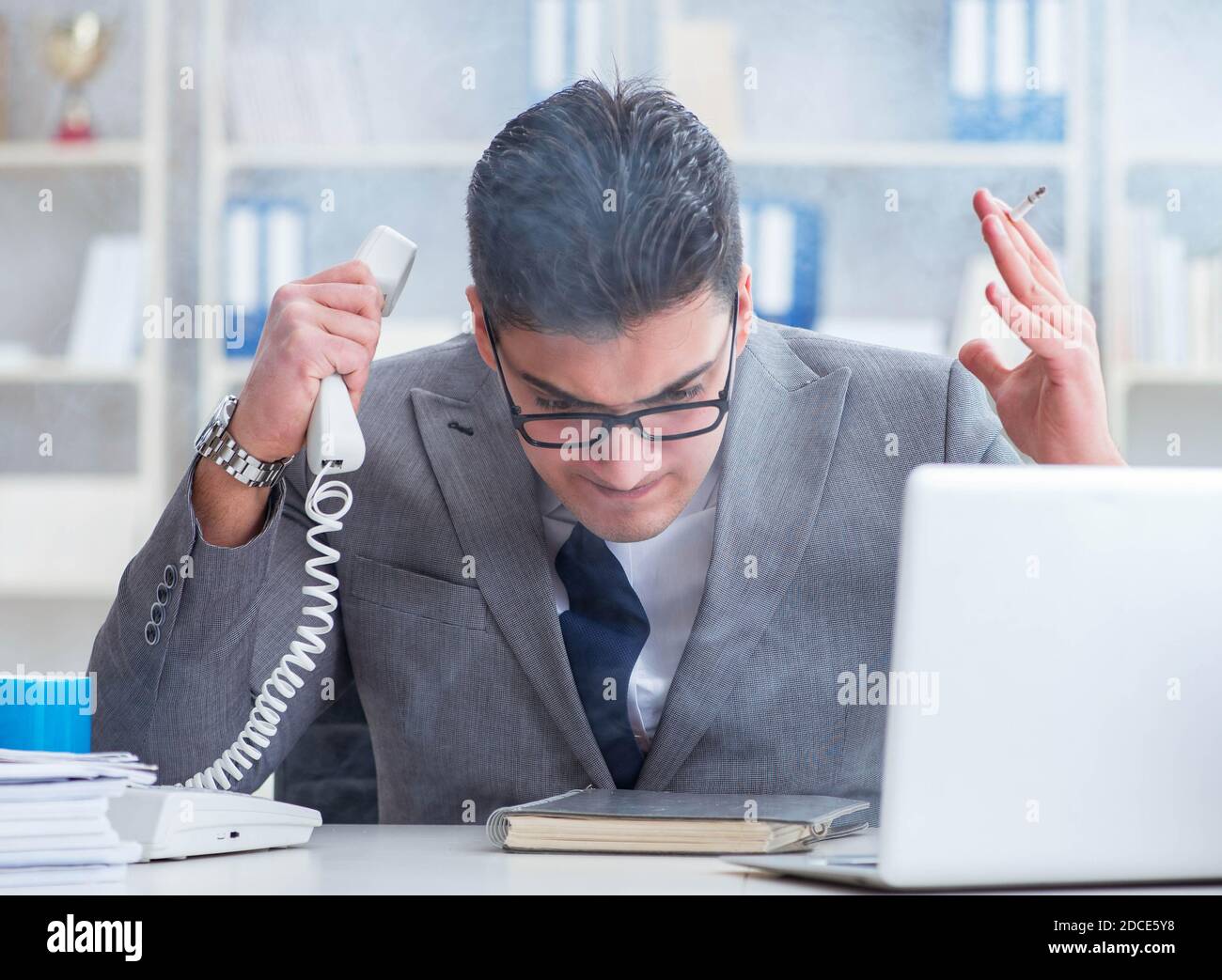 The businessman smoking in office at work Stock Photo - Alamy