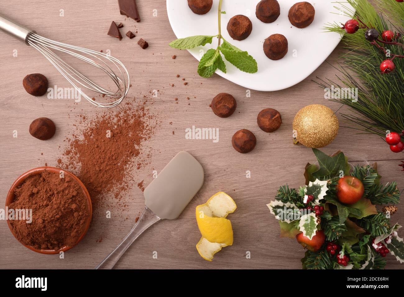 Table with chocolate truffles in preparation with Christmas decoration ...