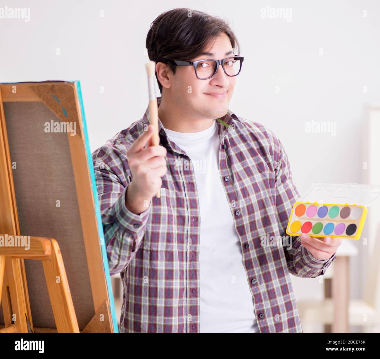 The young male artist drawing pictures in bright studio Stock Photo - Alamy