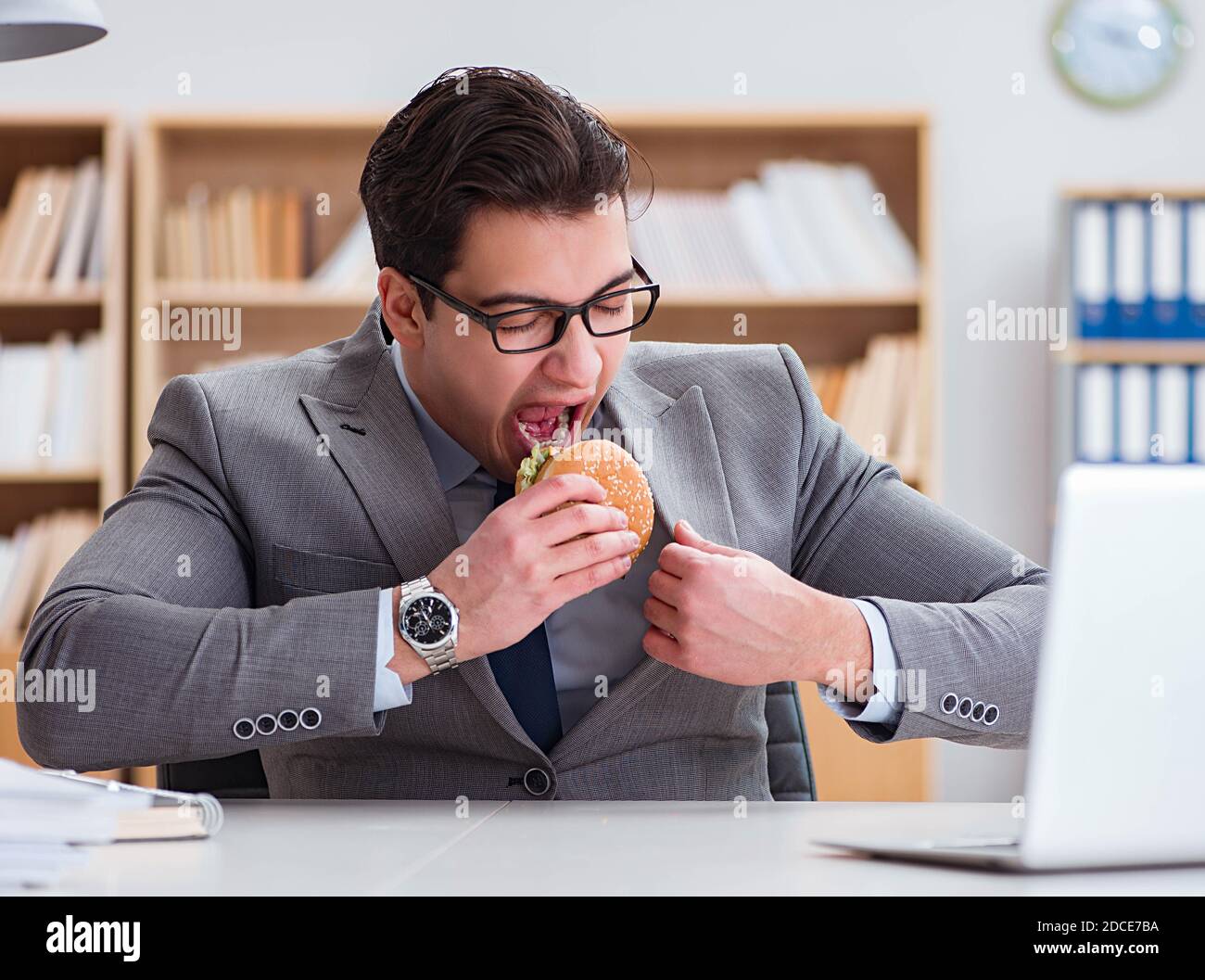 The hungry funny businessman eating junk food sandwich Stock Photo - Alamy