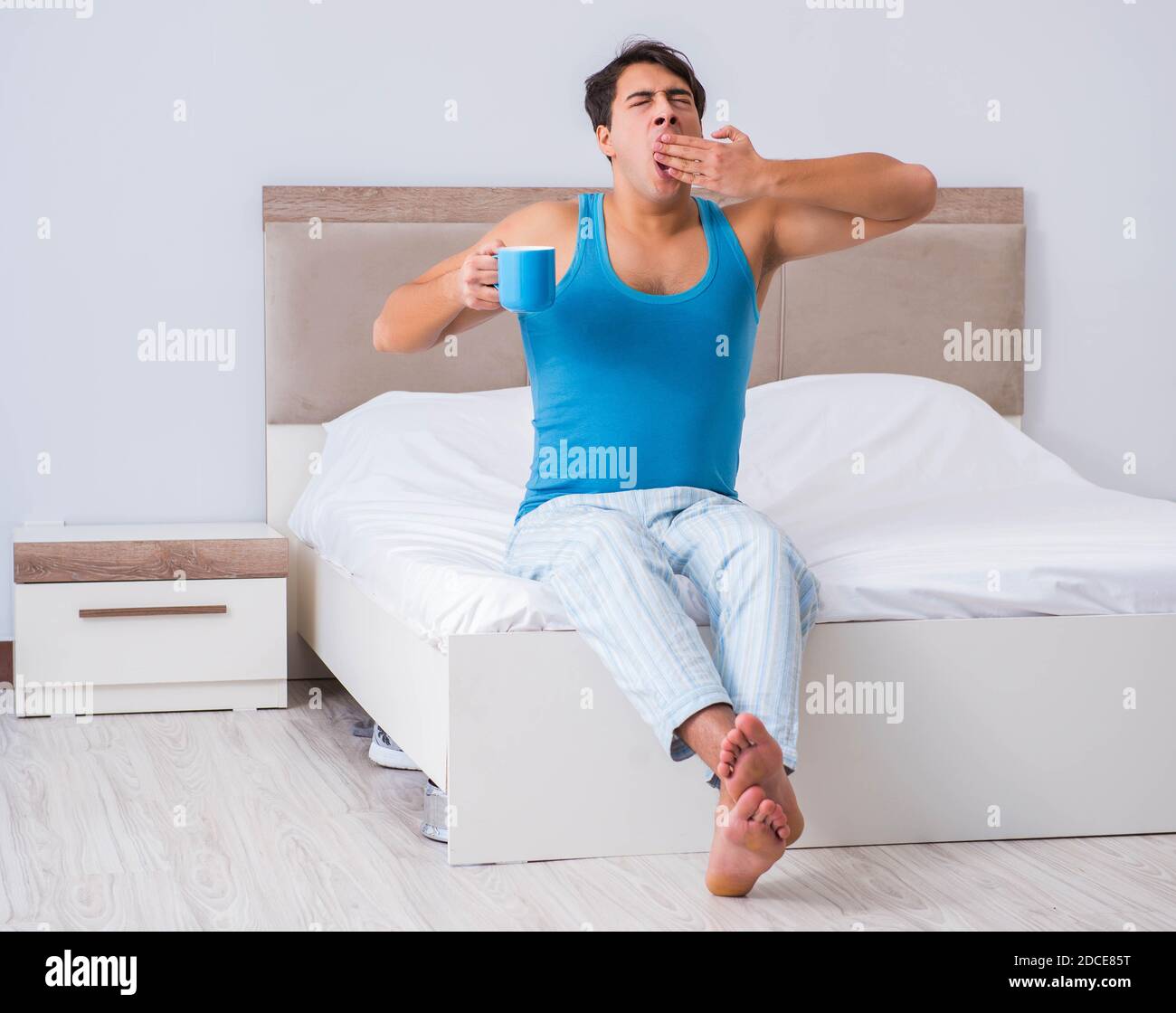 The young man waking up in bed Stock Photo - Alamy