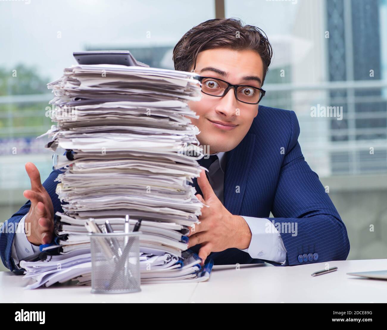 The businessman with pile stack of paper paperwork in the office Stock ...