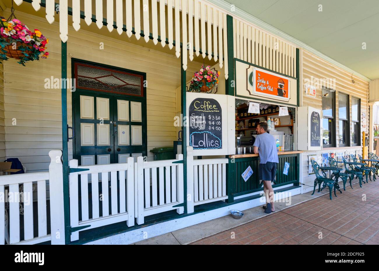 Person buying a coffee from Esk Trading Post shop, a small rural town ...