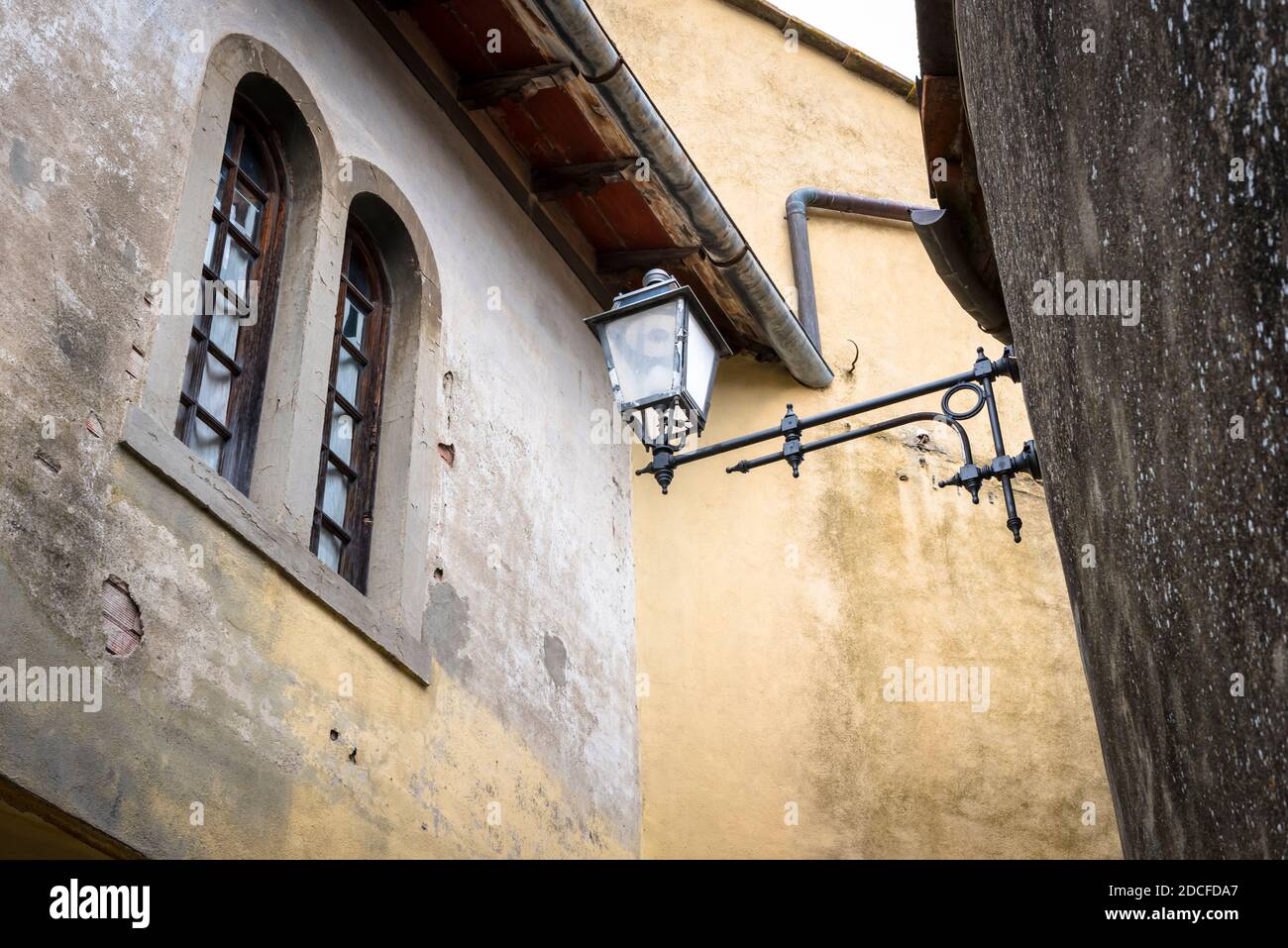 Wall with a street lamp opposite the old window of medieval form Stock ...