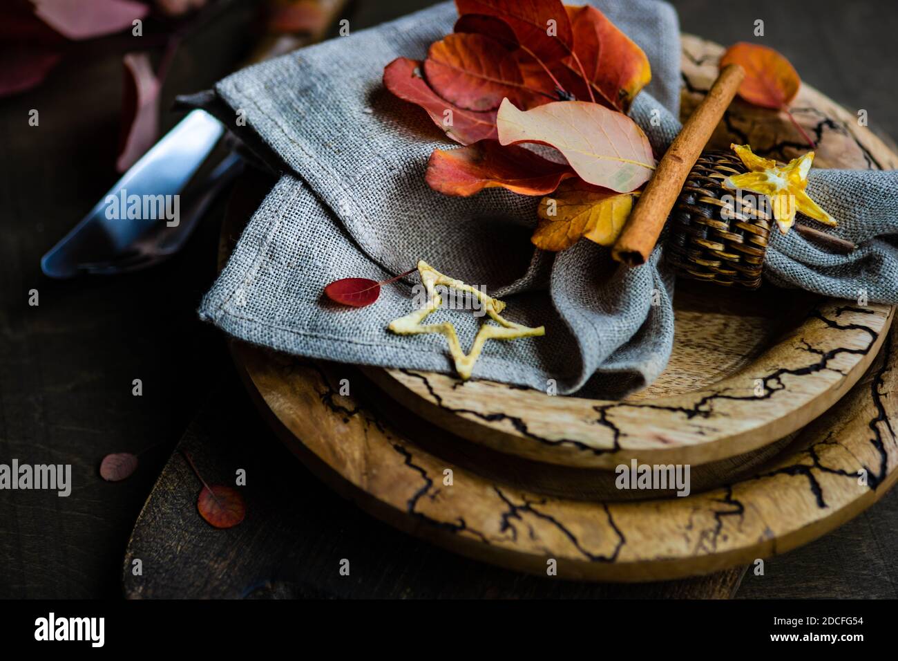 Autumnal place setting with yellow and red leaves on rustic background ...